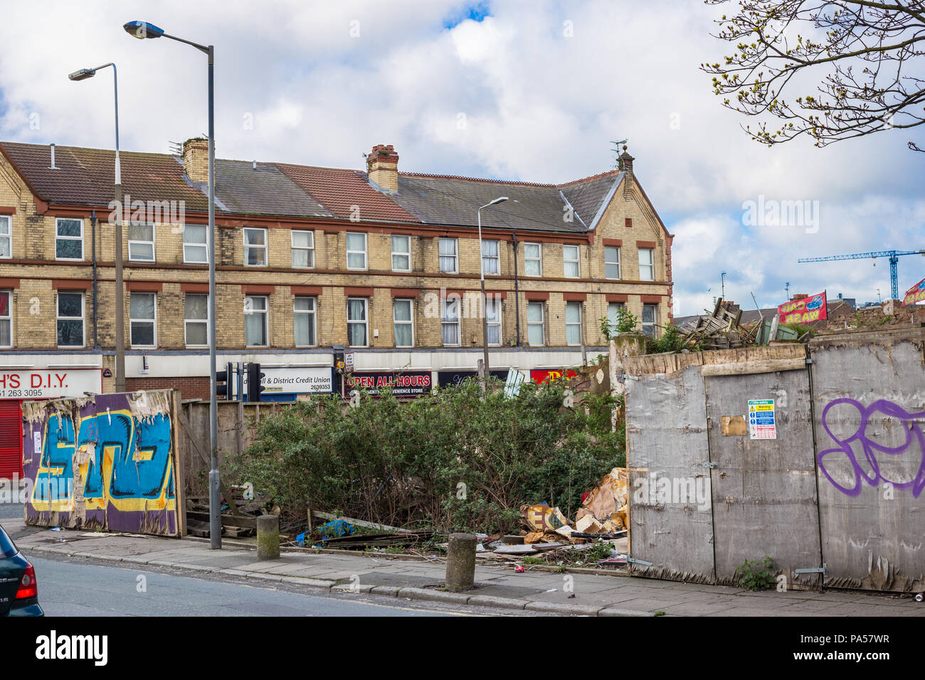 Overgrown plot showing urban decay, rundown buildings and graffiti ...