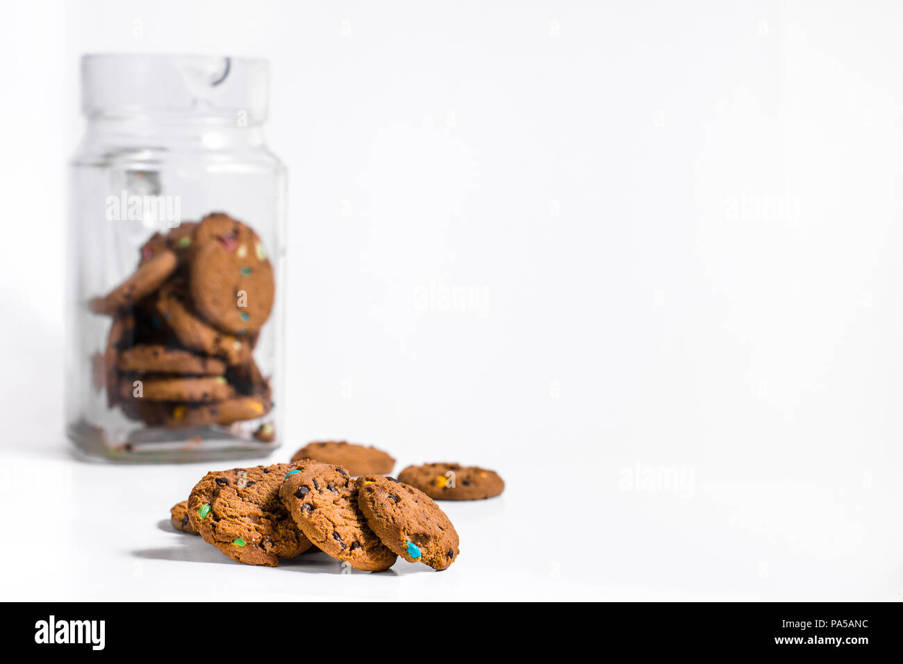 Cookie jar on white background with smartie choc chip biscuits Stock ...