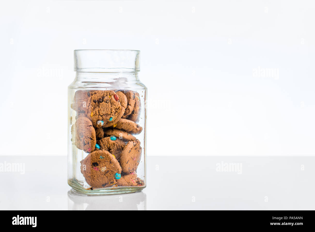 Cookie jar on white background with smartie choc chip biscuits Stock ...