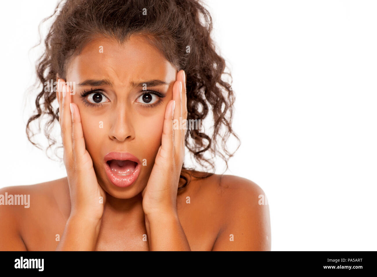 Portrait Of A Shocked Young Dark Skinned Woman On A White Background