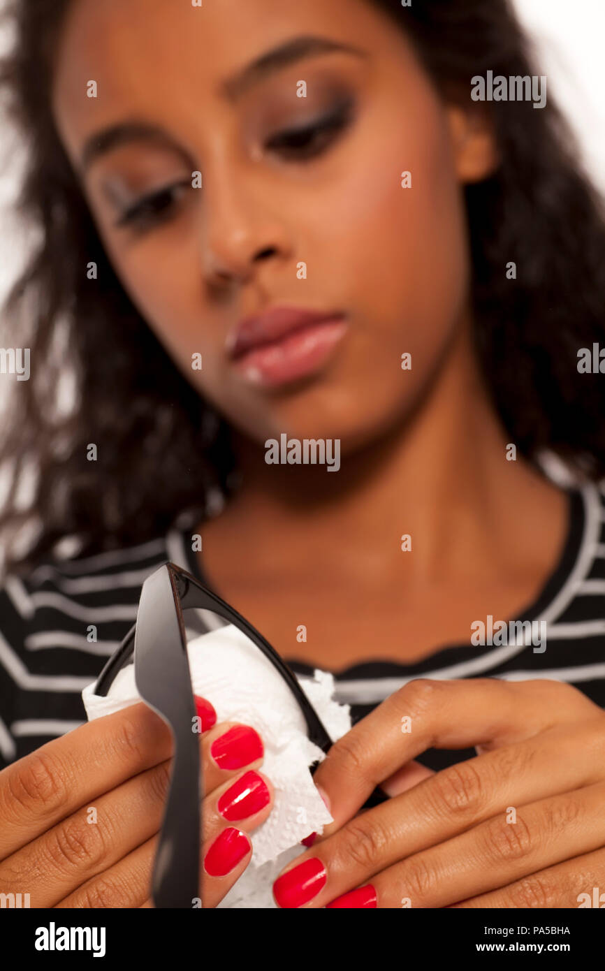 beautiful young dark skinned woman cleaning her eyeglasses Stock Photo ...