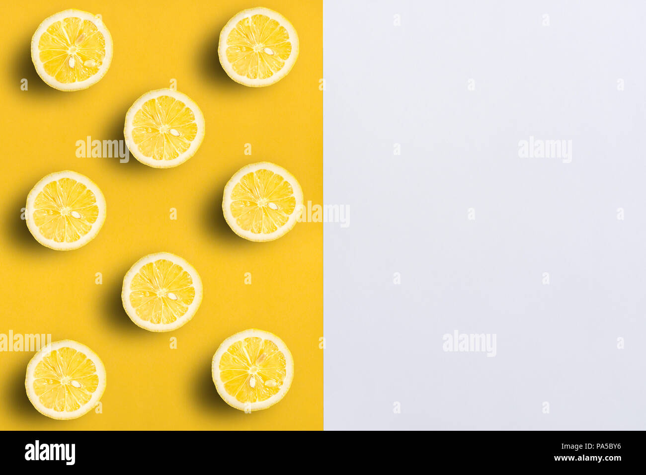 Lemon halves on split color, yellow and white background with copy ...