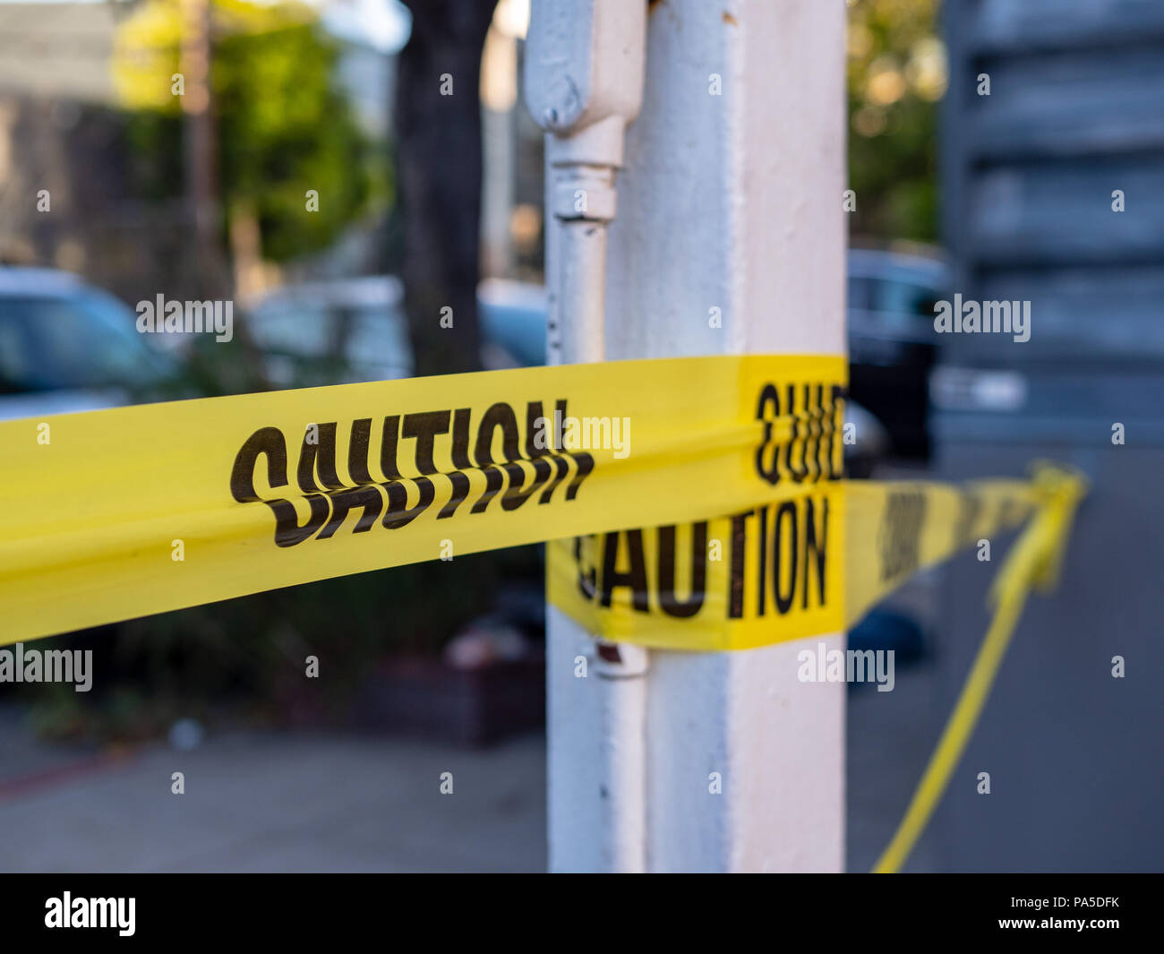 Close up of caution yellow trap hanging on a pole and blocking a path ...
