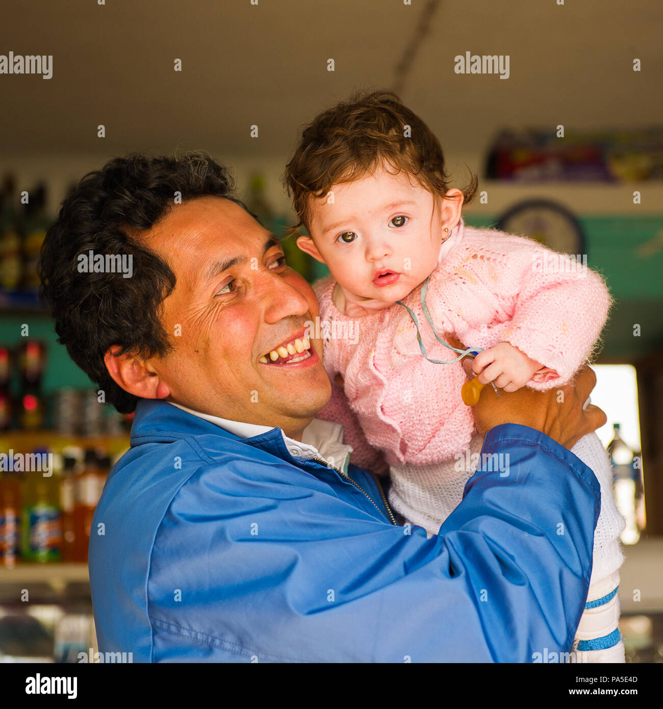 PERU - NOVEMBER 3, 2010: Unidentified happy father shop owner holds his ...