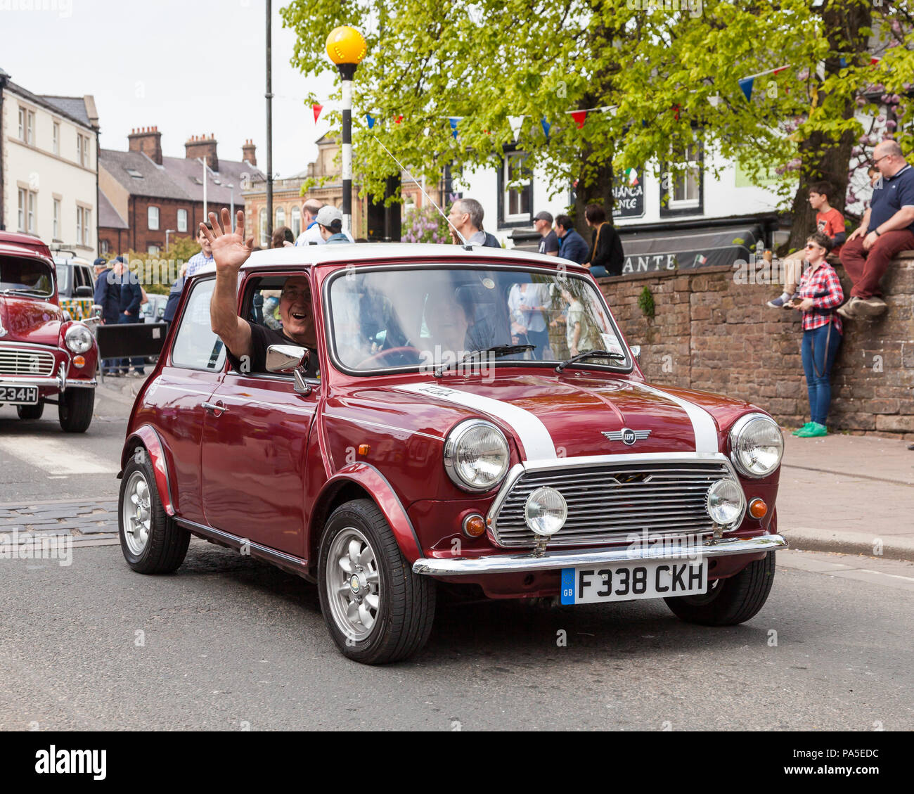 A maroon Mini Cooper take part in the annual May Day parade through ...