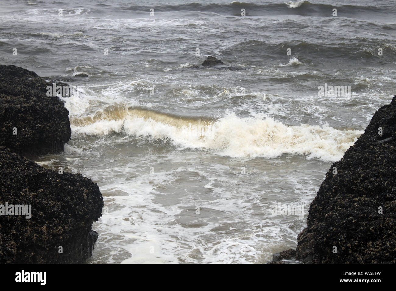 The waves breaking against the rocky shore Stock Photo - Alamy