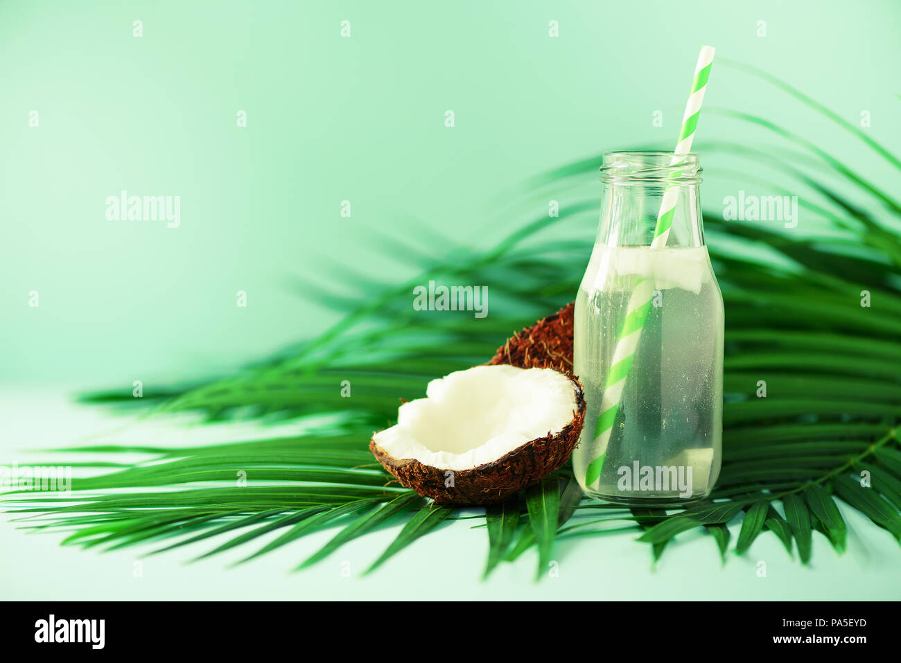 Bottle of coconut water and fresh ripe fruits on blue background ...