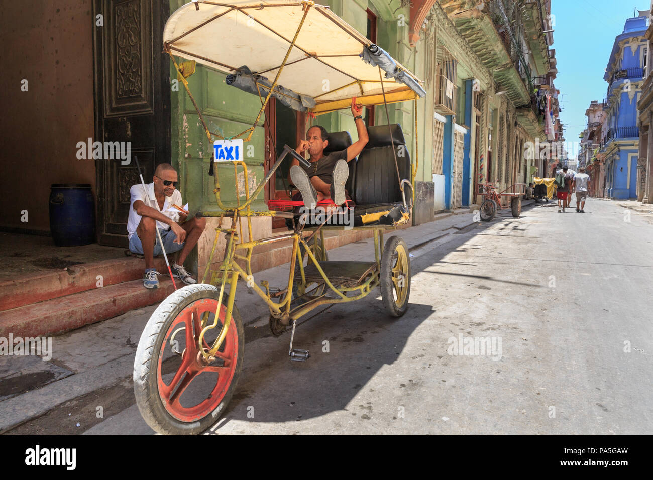 Bicycle taxi and waiting driver in a street scene in Habana Vieja ...