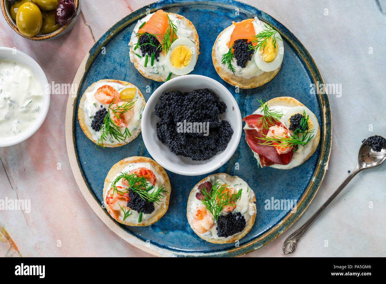Selection of cocktail blinis with salmon, cured bresaola, crayfish ...