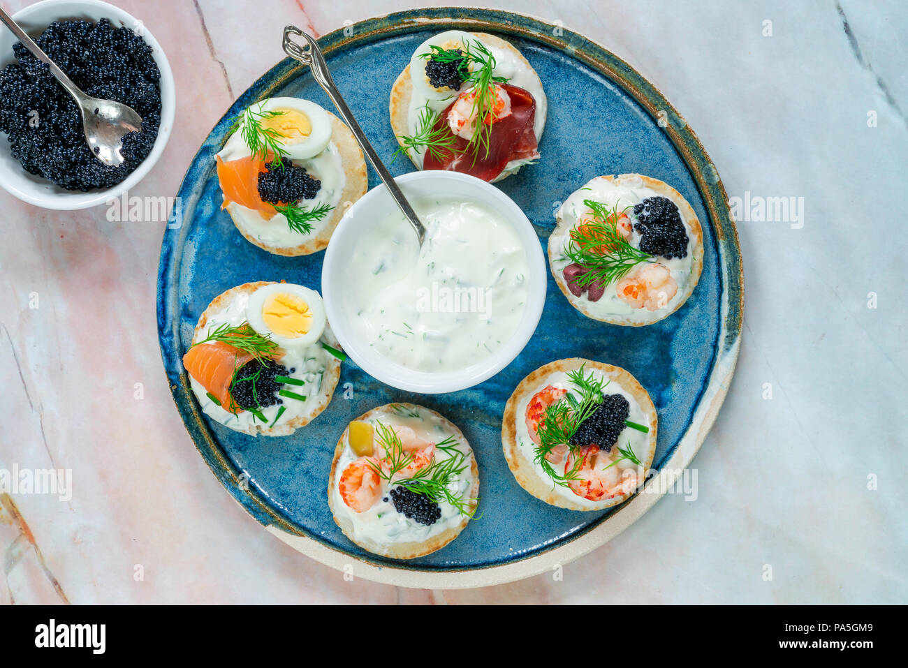 Selection of cocktail blinis with salmon, cured bresaola, crayfish ...