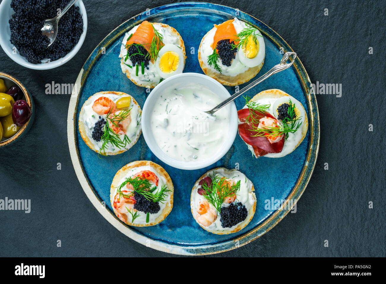 Selection of cocktail blinis with salmon, cured bresaola, crayfish ...