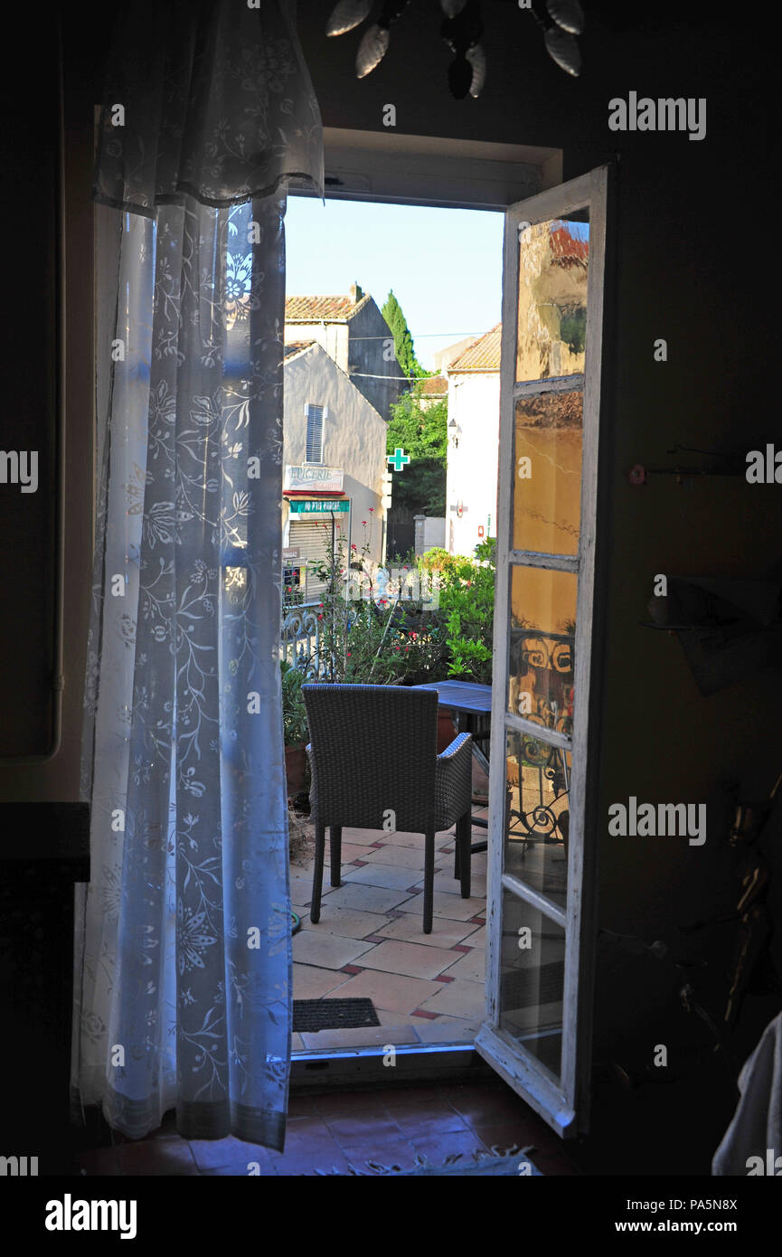 Early morning looking out of an open window and shutters leading to the ...