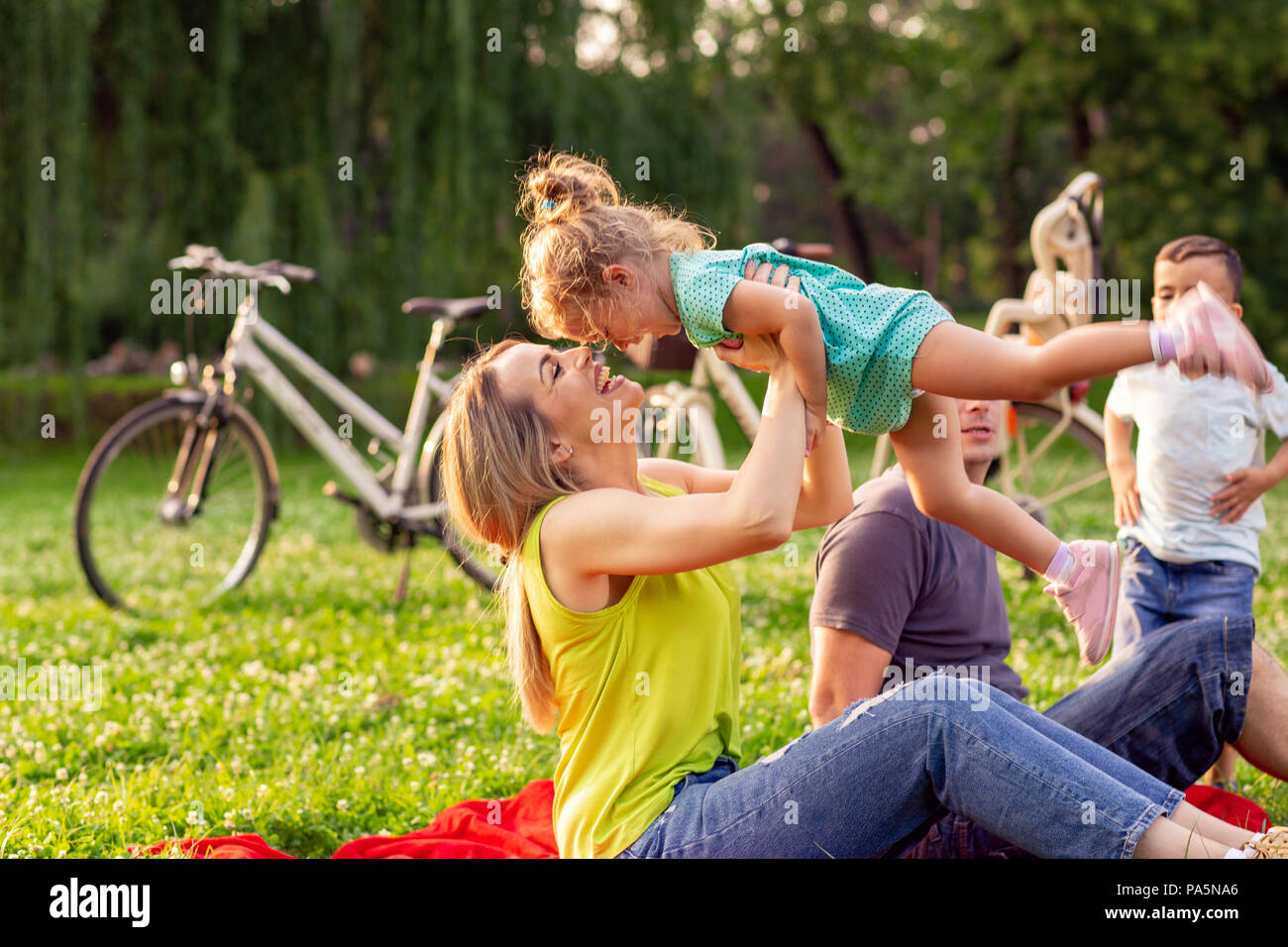 Happy family time- Young mother raising her smiling girl child up Stock ...