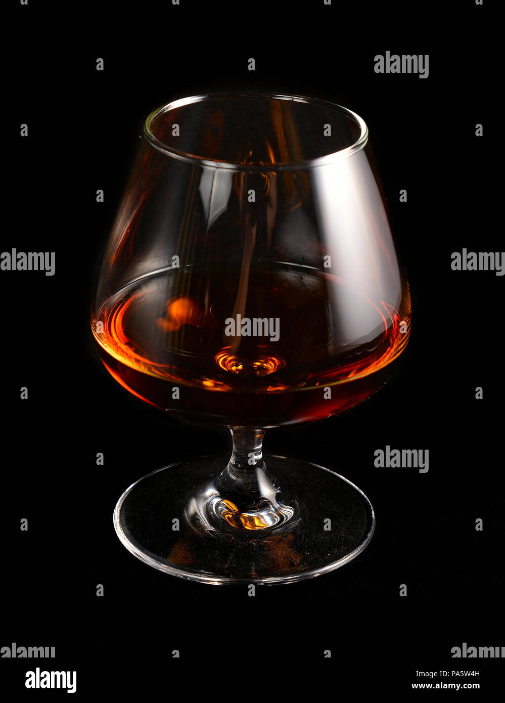 Glass of brandy over black background Stock Photo - Alamy