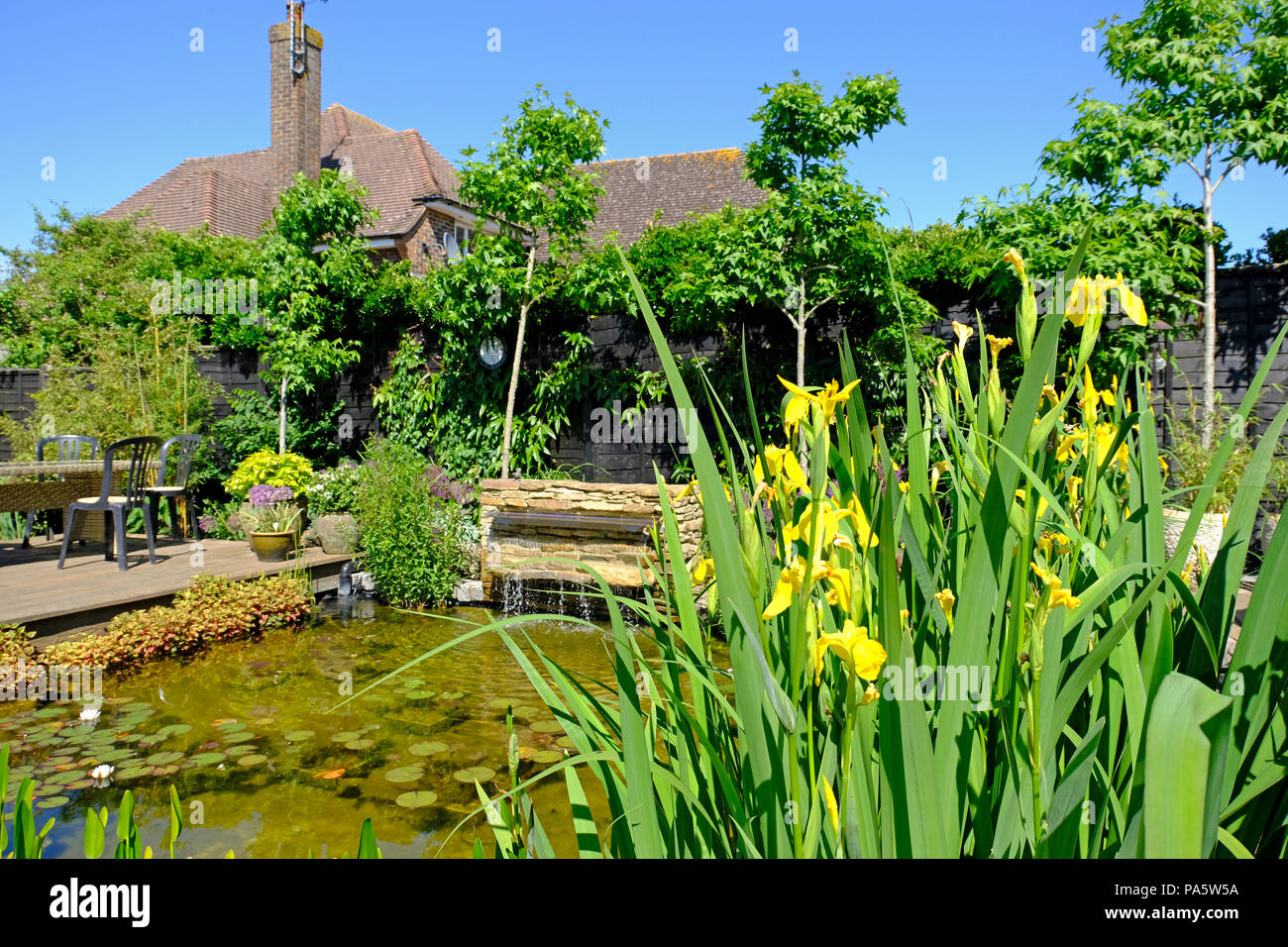 Contemporary fish pond with stainless steel waterfall Stock Photo - Alamy