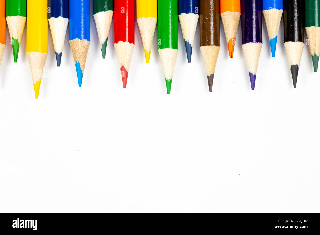 Color pencils lined up in a row against a white background Stock Photo - Alamy