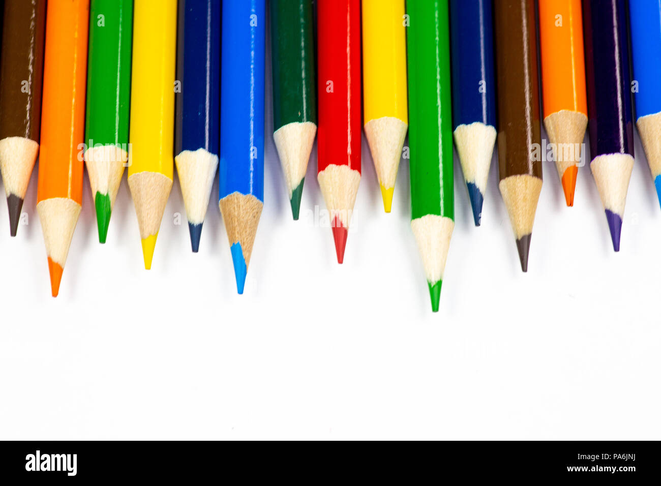 Color pencils lined up in a row against a white background Stock Photo - Alamy