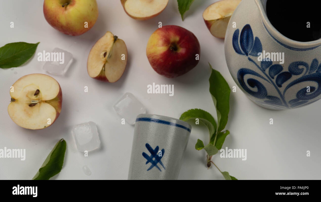 Traditional Frankfurt apple wine in a jug bembel with beaker and apples ...