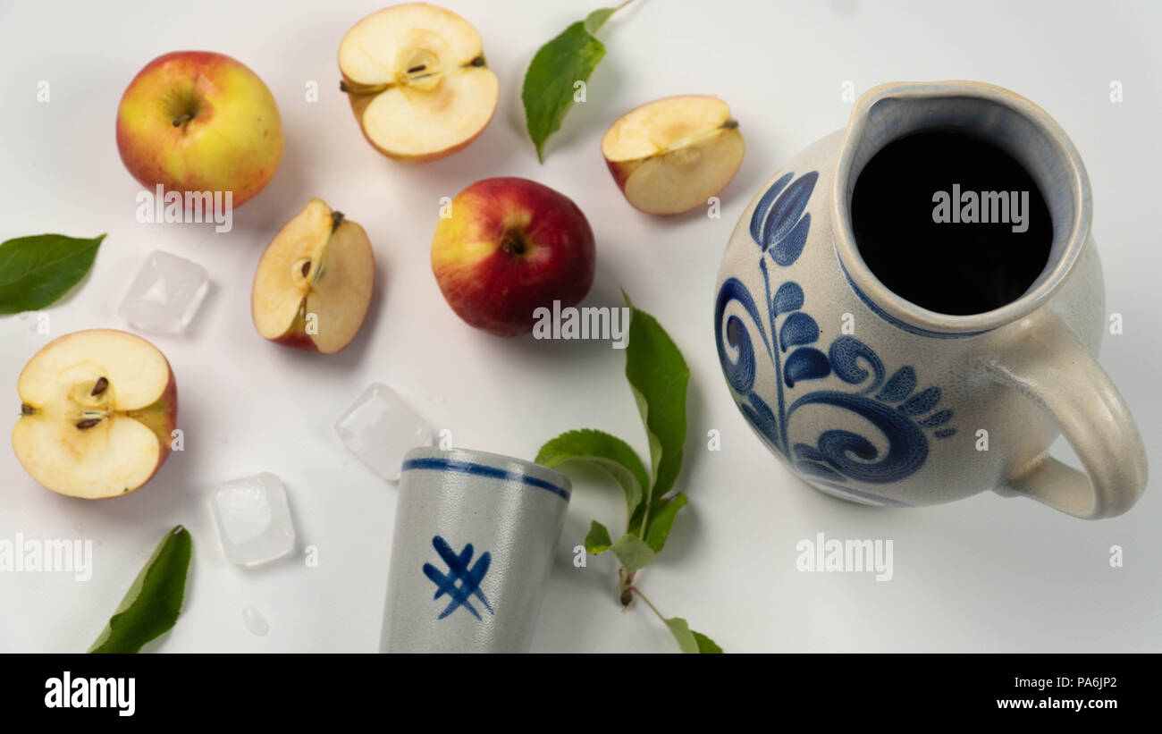 Traditional Frankfurt apple wine in a jug bembel with beaker and apples ...
