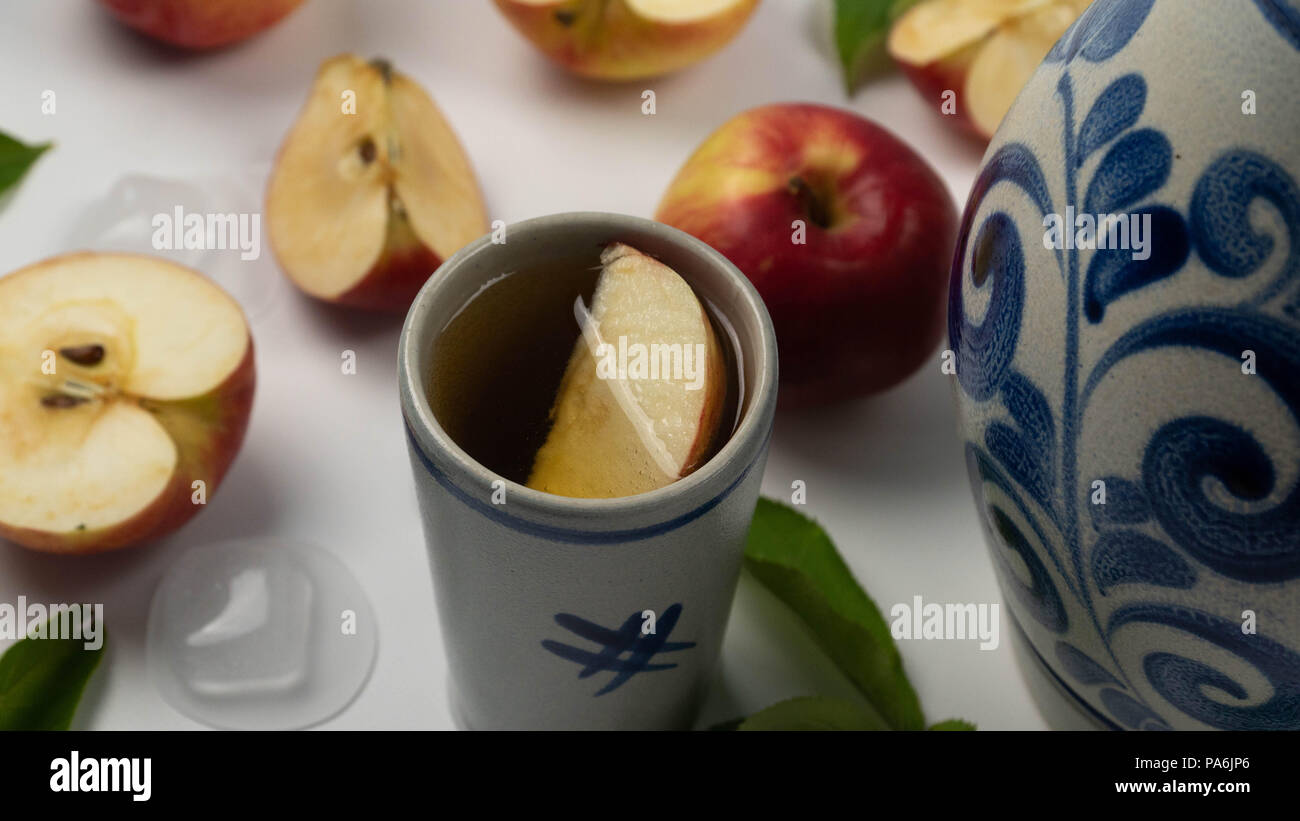 Traditional Frankfurt apple wine in a jug bembel with beaker and apples ...