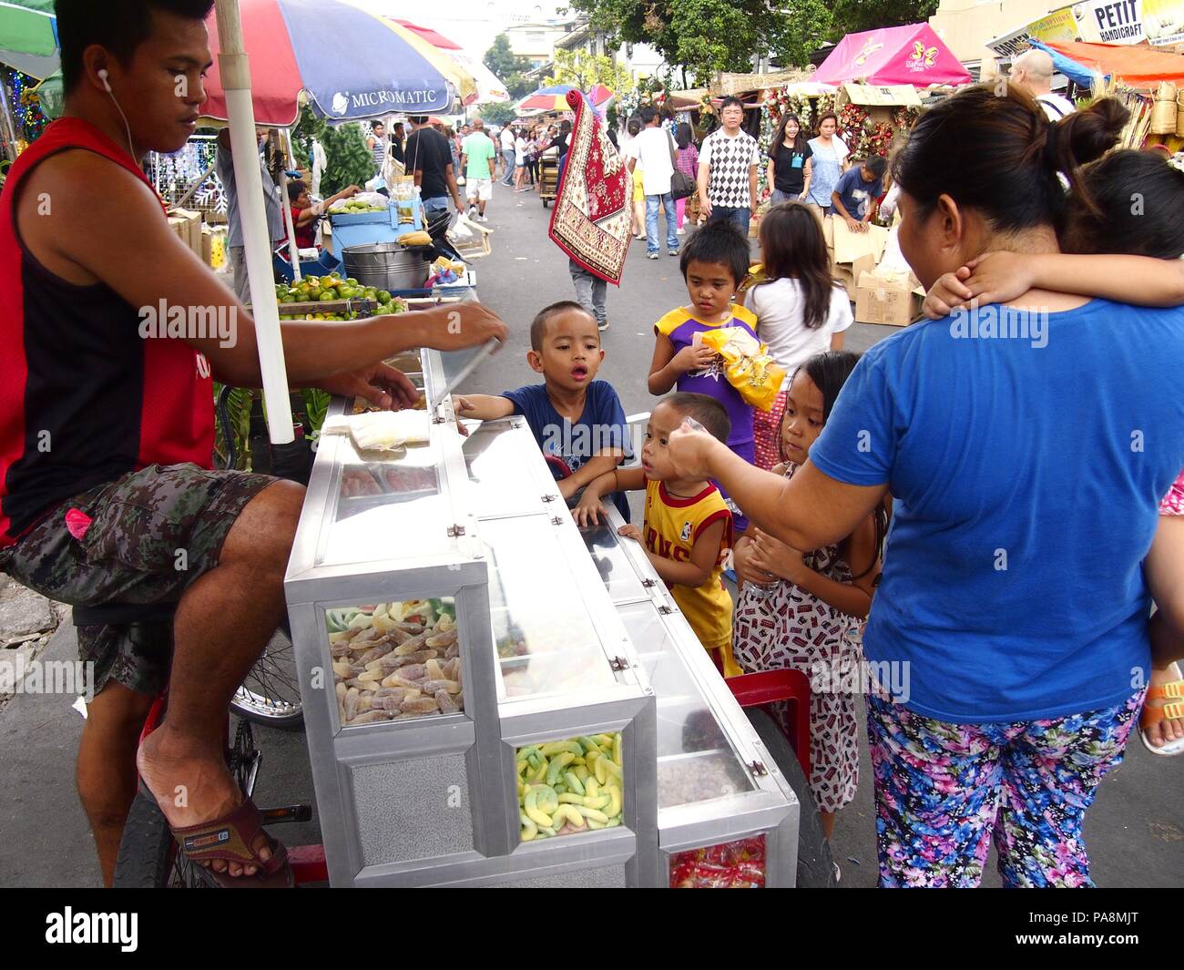 QUEZON CITY, PHILIPPINES - NOVEMBER 22, 2015: Children buy candies and ...