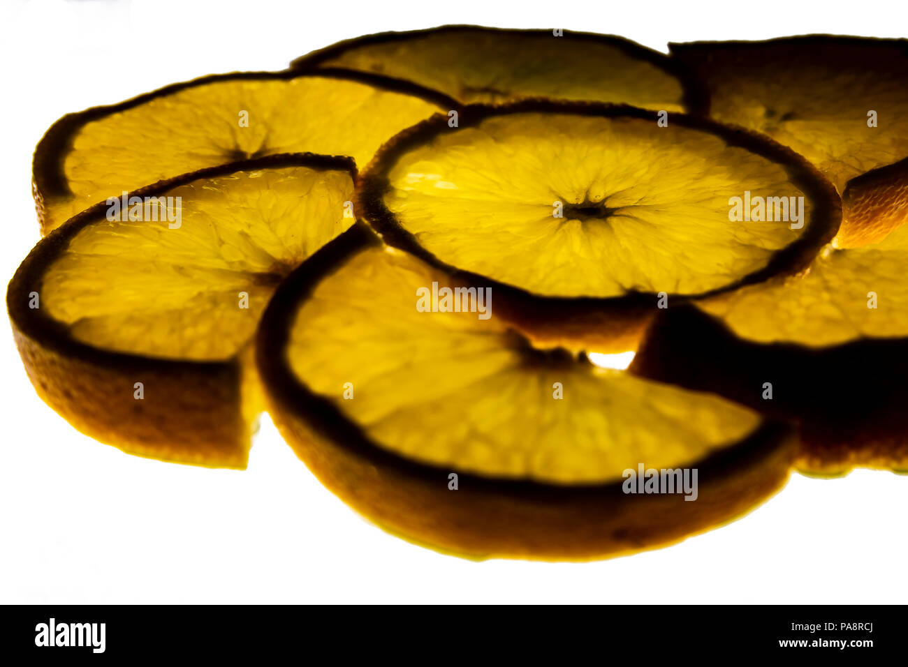 Slices of juicy citric fruit with back light and a white background ...