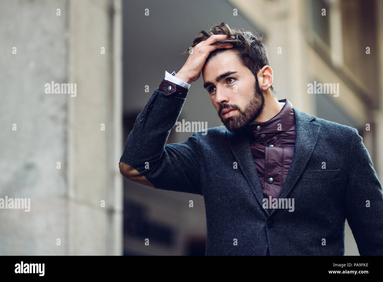 Young bearded man, model of fashion, in urban background wearing ...