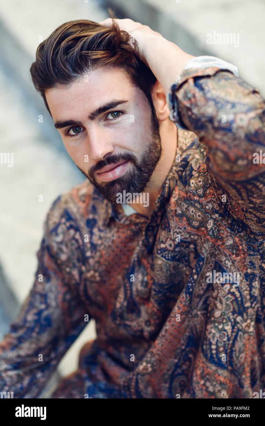 Young smiling man, model of fashion, wearing modern shirt in the street ...