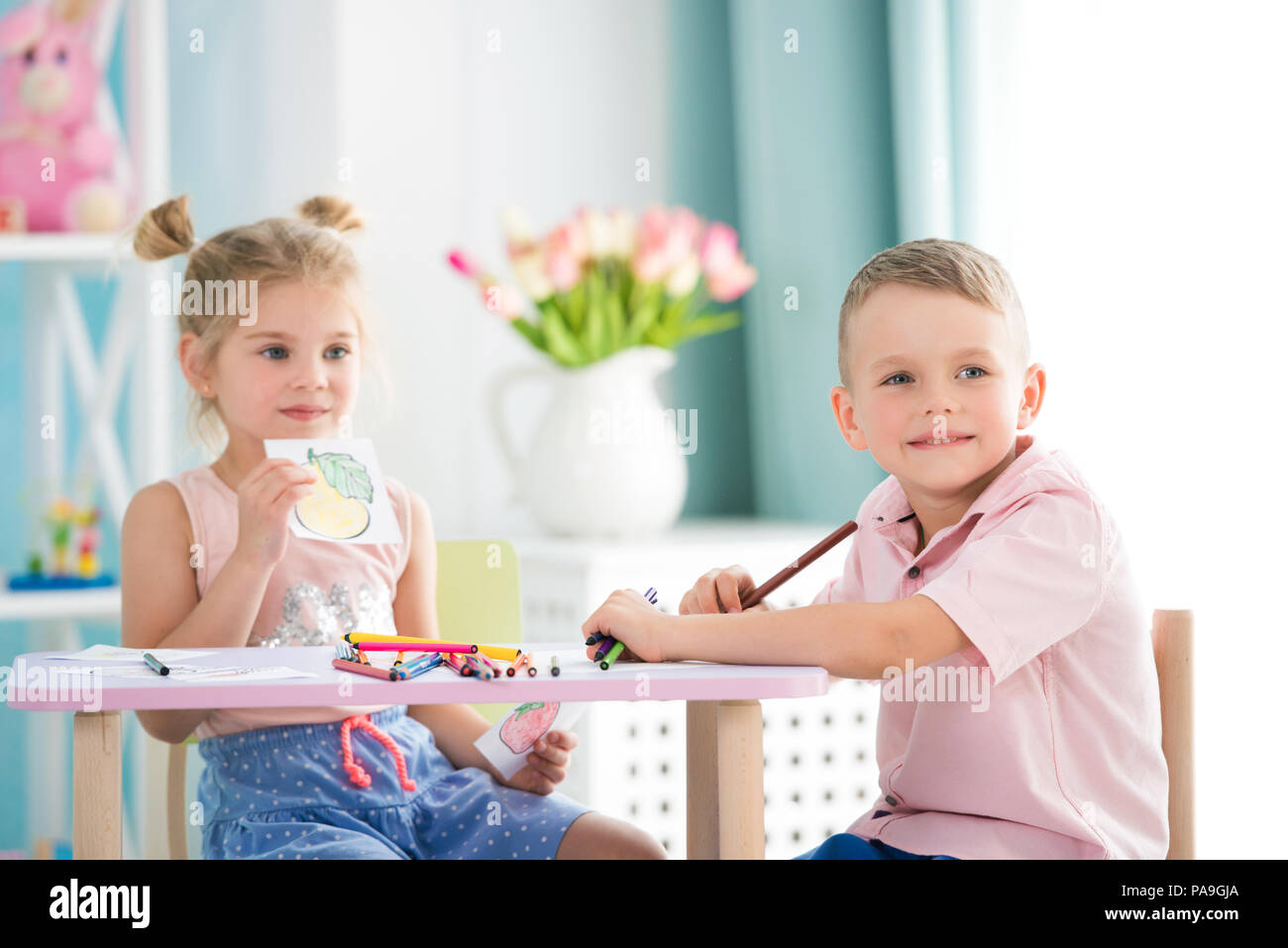 Little children play and draw with colorful pencils Stock Photo - Alamy