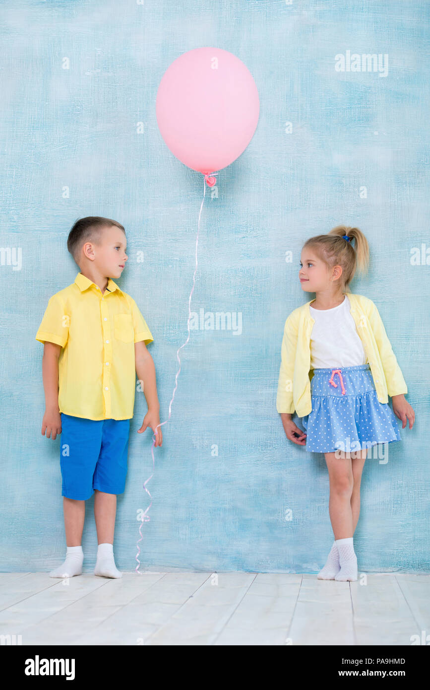 Boy child gives a balloon to a girl. Signs of attention, sympathy and ...