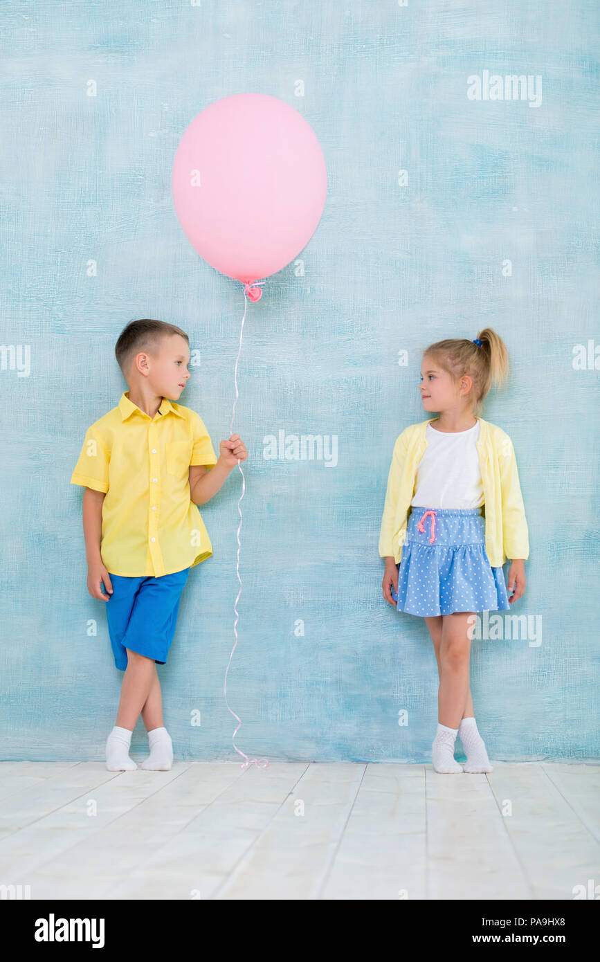 Boy child gives a balloon to a girl. Signs of attention, sympathy and ...