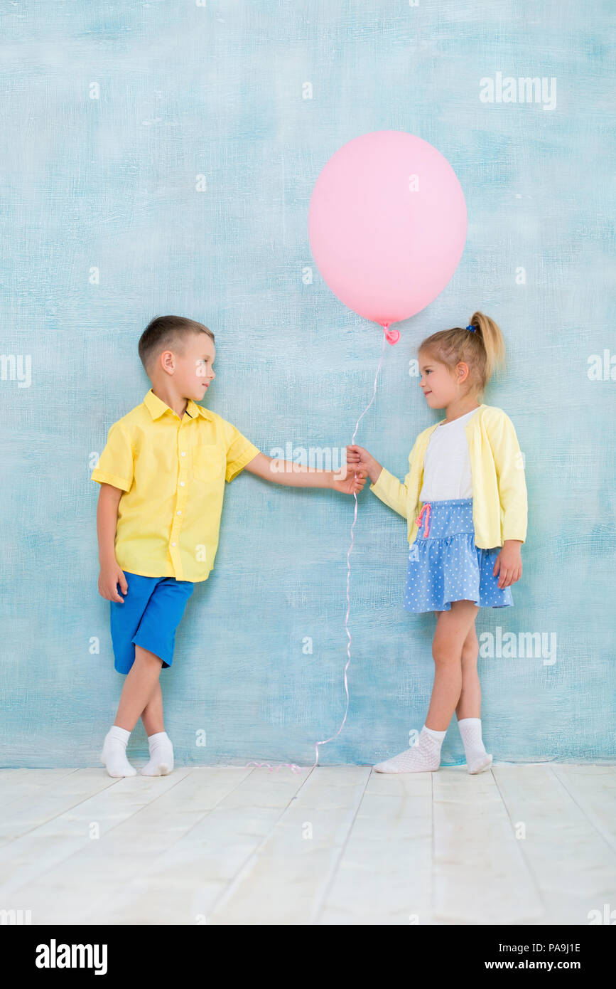 Boy child gives a balloon to a girl. Signs of attention, sympathy and ...