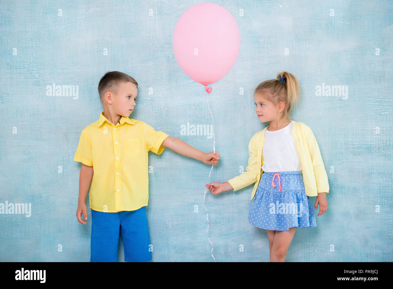 Boy child gives a balloon to a girl. Signs of attention, sympathy and ...