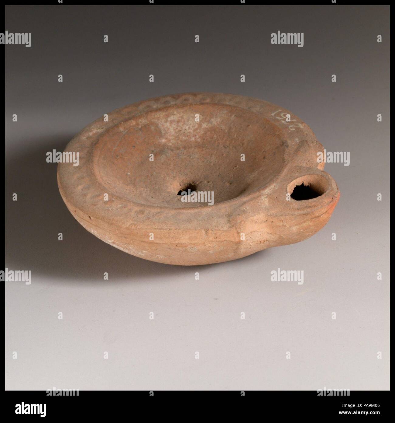 Lamp. Culture: Roman. Dimensions: Length: 3 1/8 in. (8 cm) Height: 1 in ...