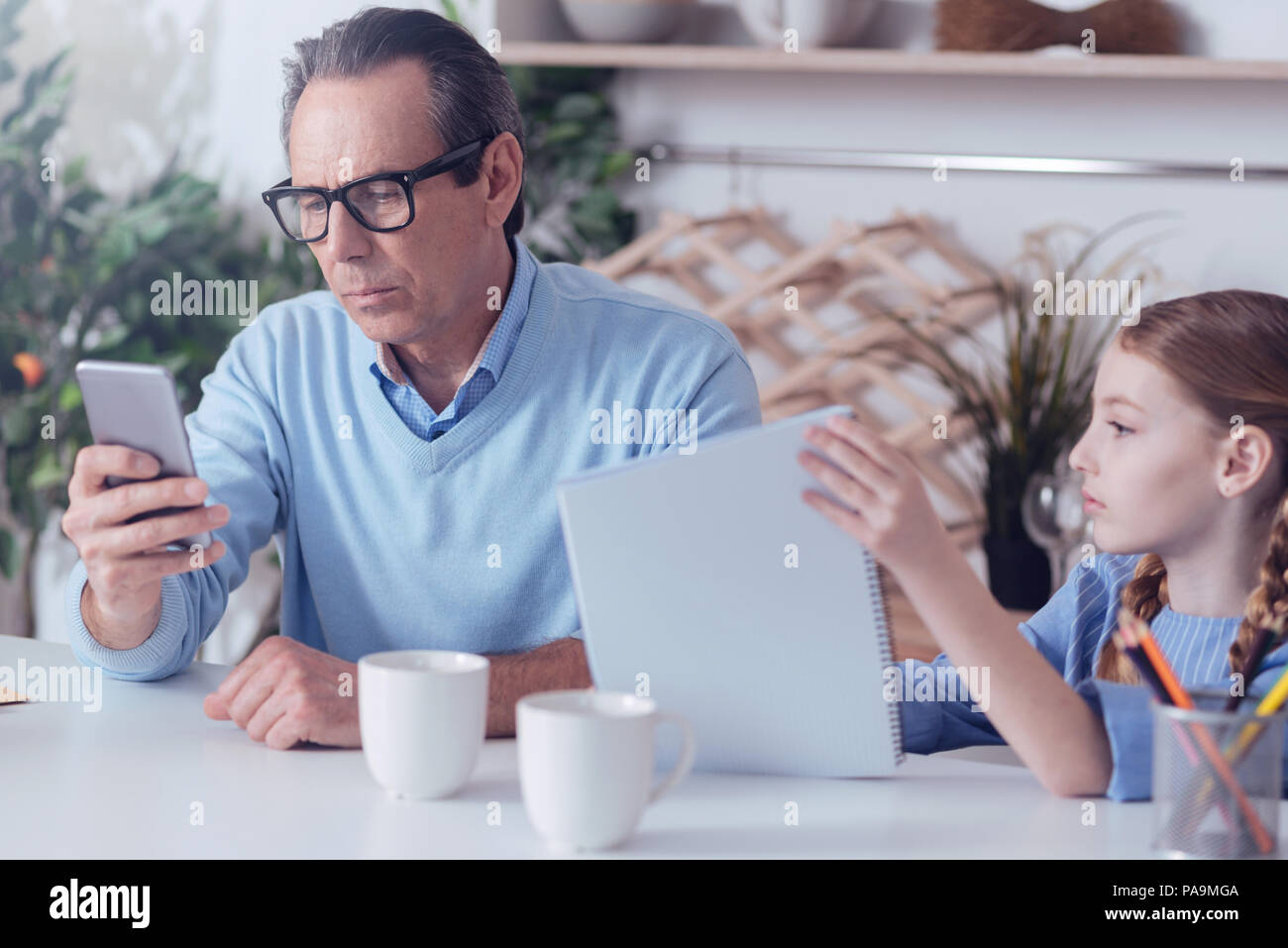 Serious handsome man paying no attention to his daughter Stock Photo ...