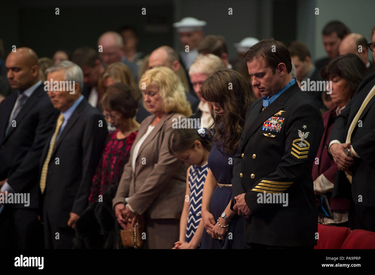 Navy Senior Chief Edward Byers and his family bow their heads during ...