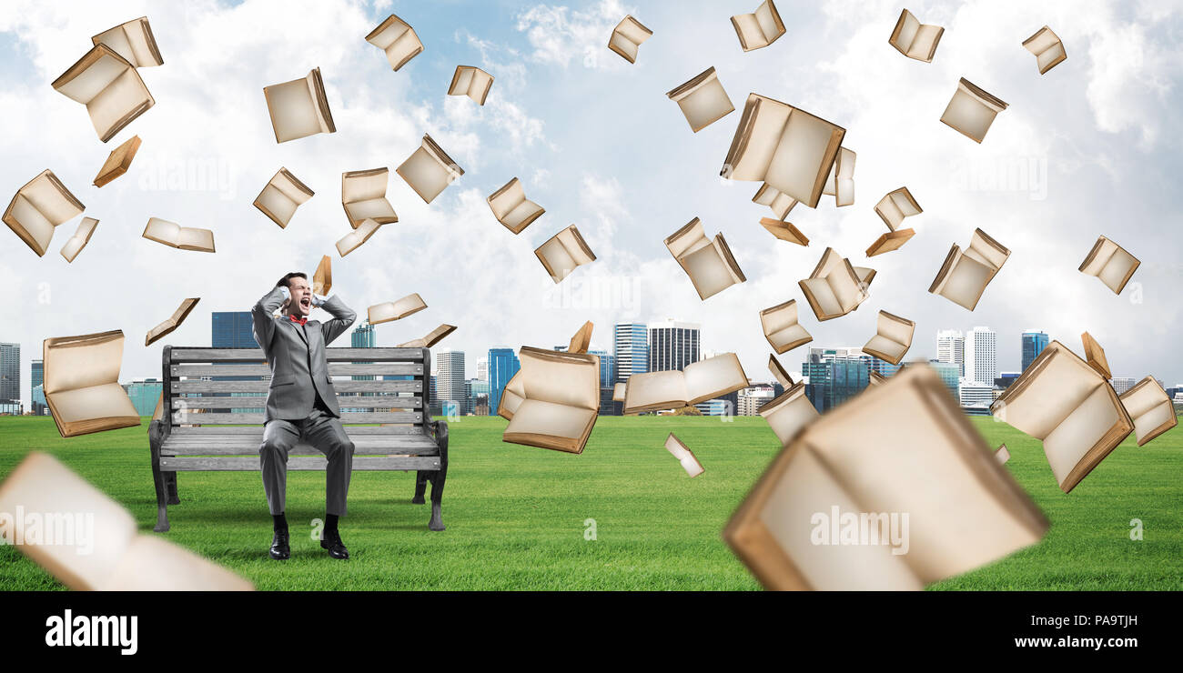 Many old books falling from above and student guy sitting on bench ...