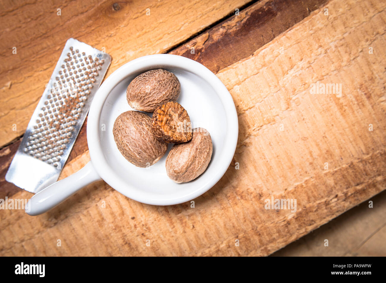 Exotic spices concept organic Dry nutmeg in white cup on wood ...
