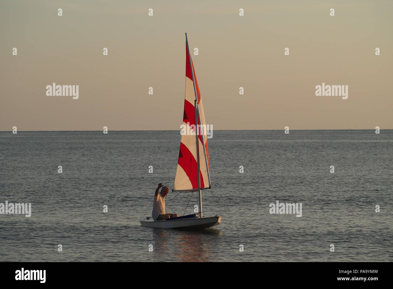 Active senior sailing a Sunfish off the beach in Captiva Island ...