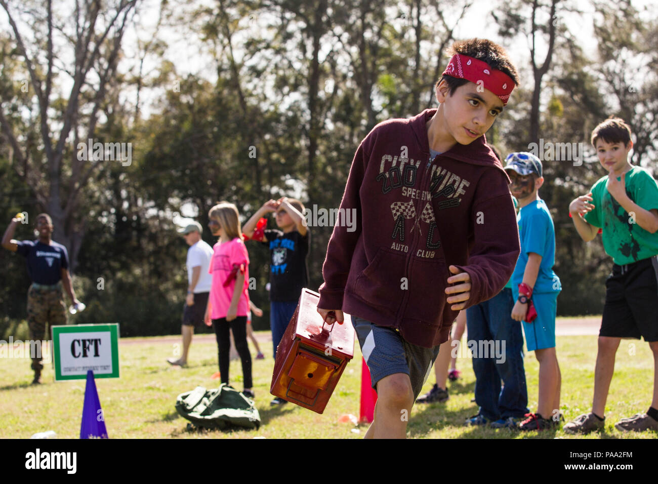 A child carries an ammo can through a modified combat fitness test ...