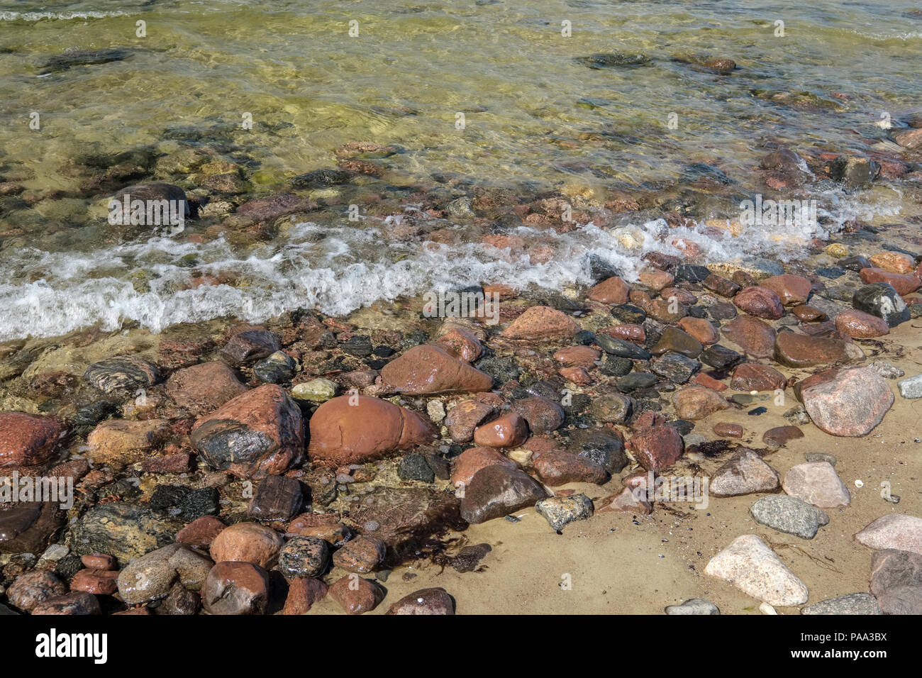 rocky sea beach with wide angle perspective over the sea with sunny sky ...