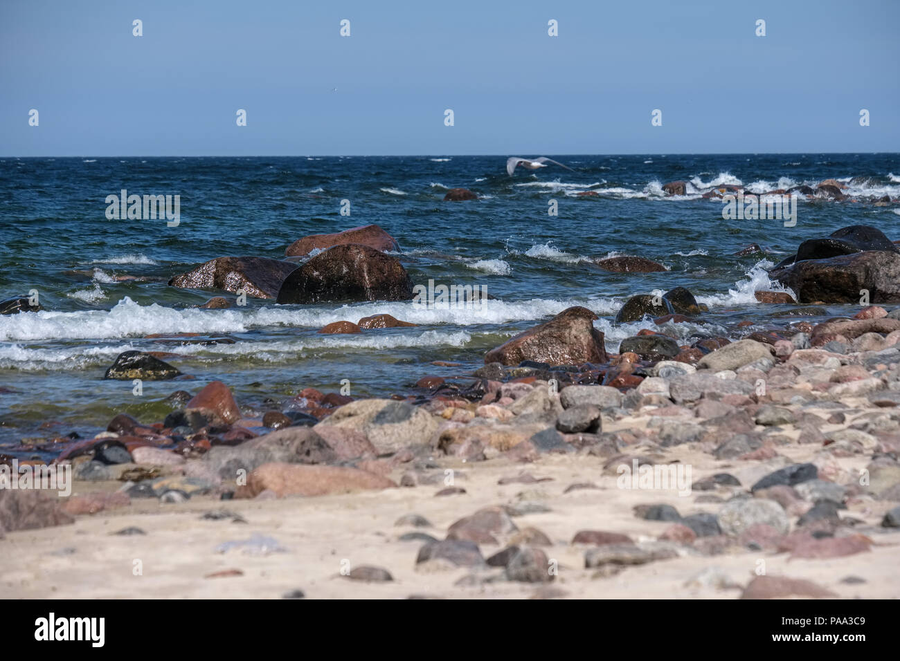 rocky sea beach with wide angle perspective over the sea with sunny sky ...