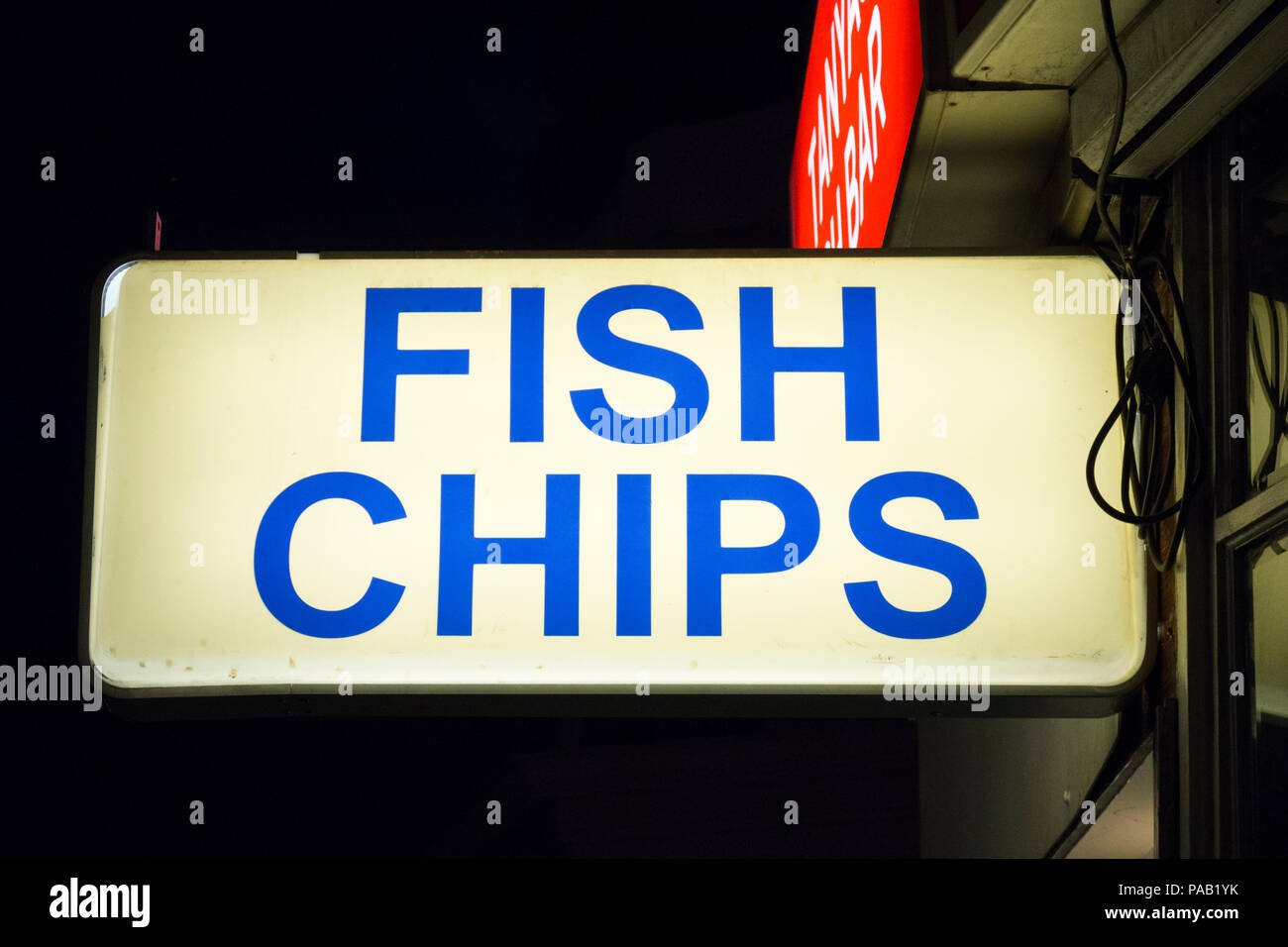 Fish and chip shop sign illuminated at night hi-res stock photography ...