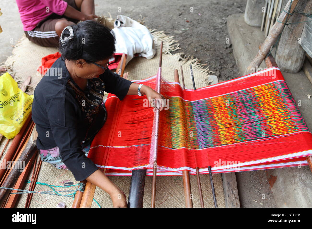 women engaged in traditional weaving at the indonesian island of ...