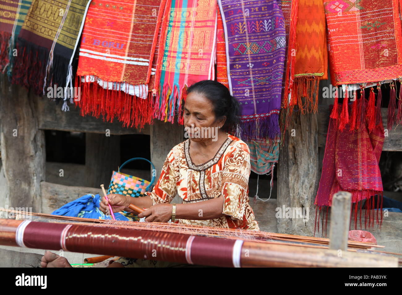 women engaged in traditional weaving at the indonesian island of ...