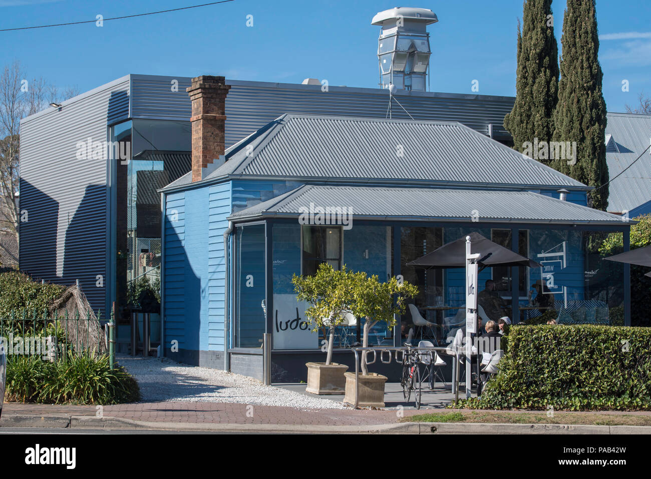A small timber historic workers cottage with a single chimney and ...