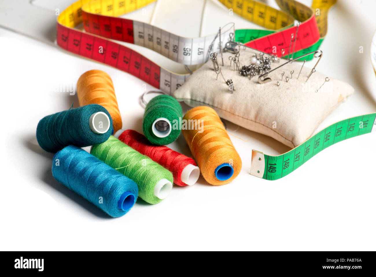 Sewing background with color threads and meter Stock Photo - Alamy