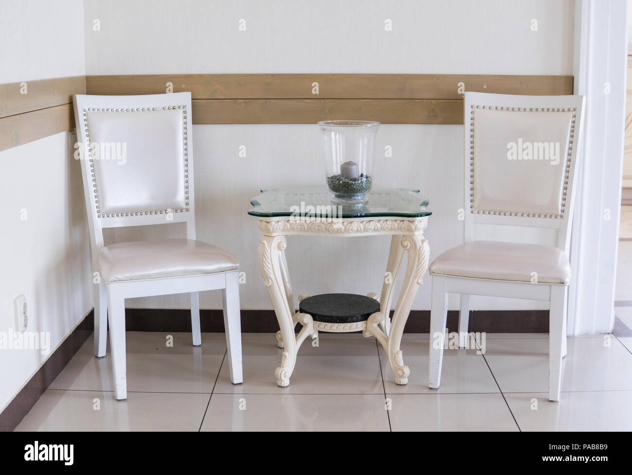 Vintage white chair and table with a candle Stock Photo - Alamy