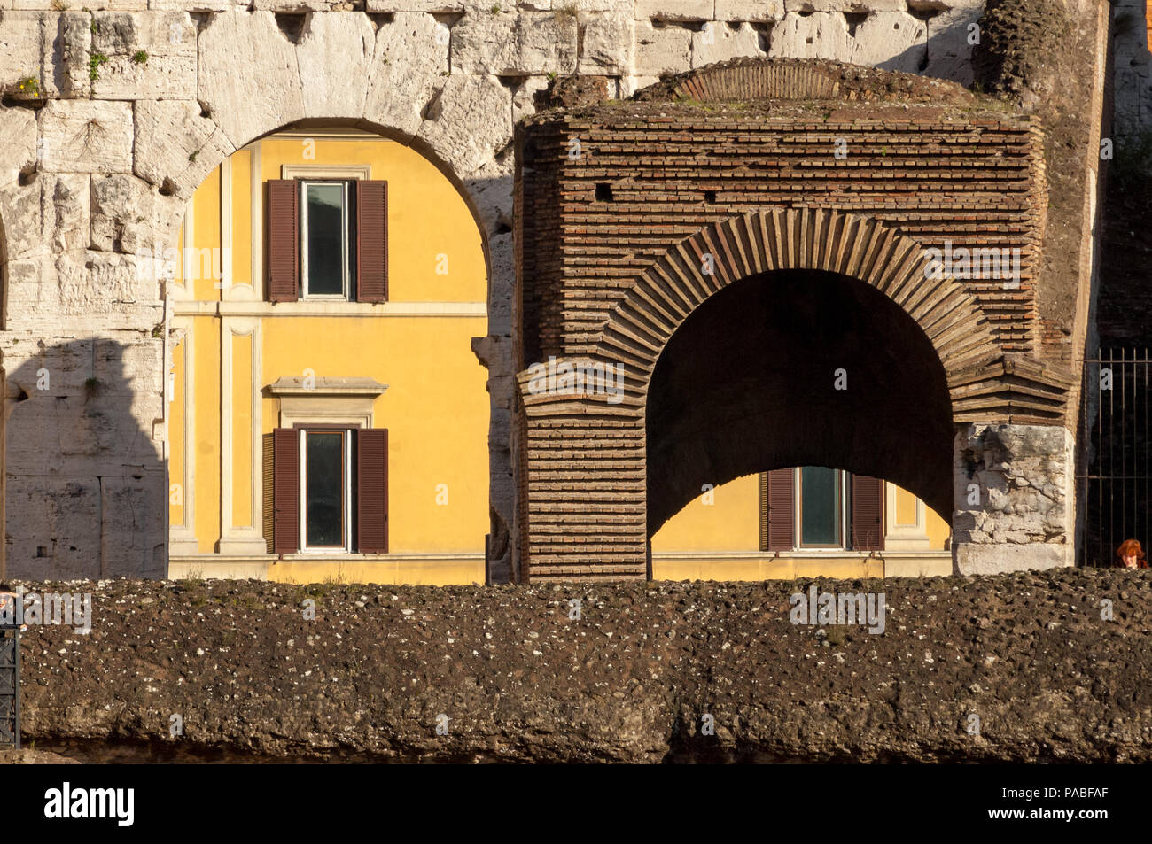 Stone and brick arches of the eastern wall of the Colosseum frame a ...