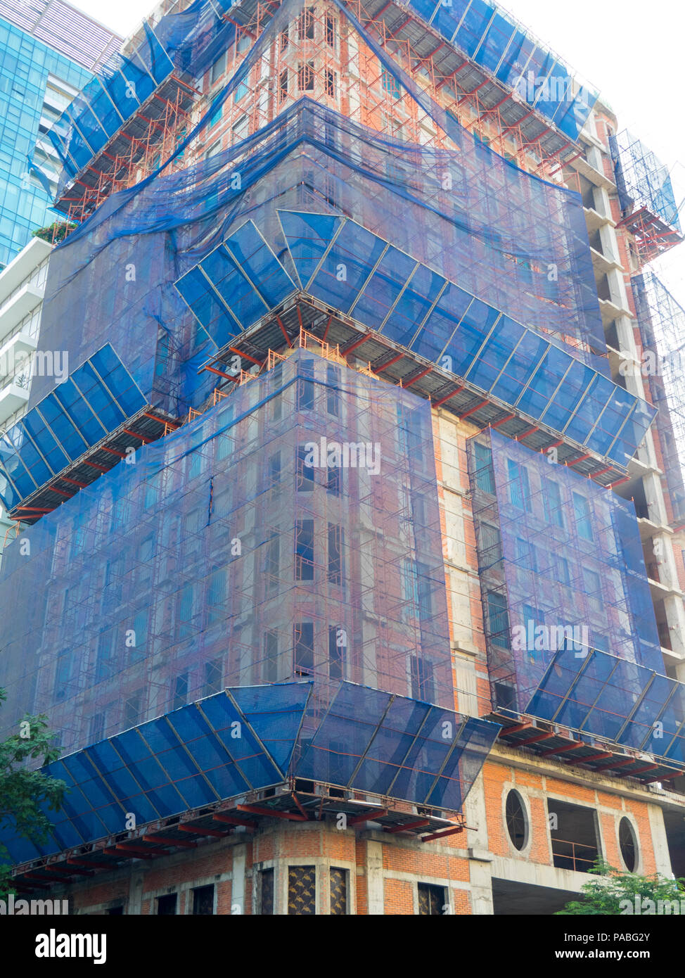 Scaffolding a blue safety netting around a construction site of a ...